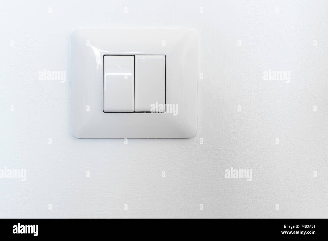 White light switch on white wall Stock Photo - Alamy
