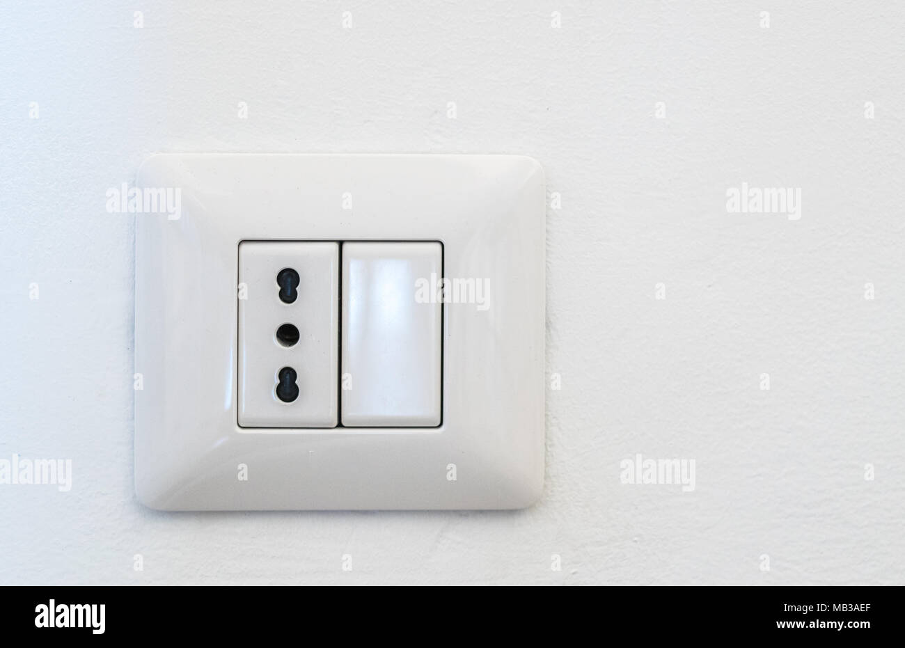 White electric socket on white wall Stock Photo - Alamy