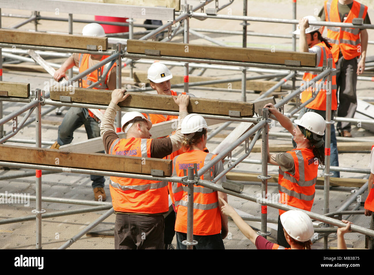 A group of workers building a temporary concert stage using scaffolding ...