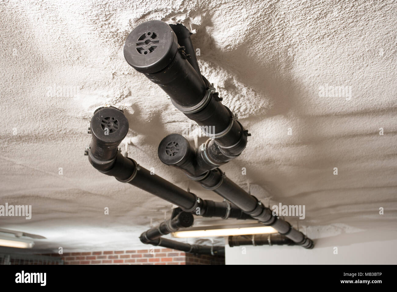 Sewage waste pipe system track emerging into a underground car park ...