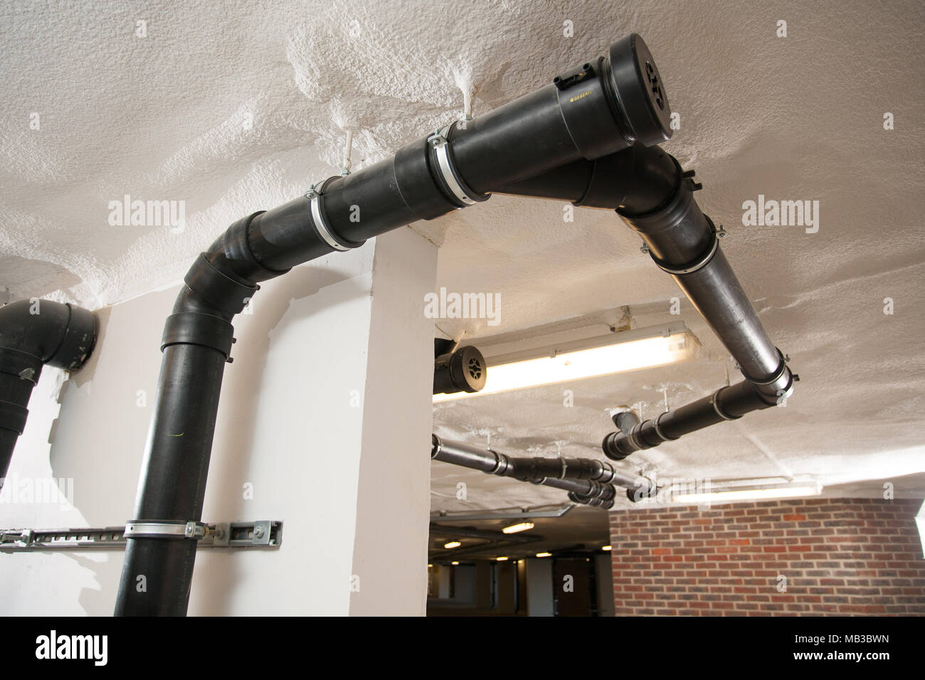 Sewage waste pipe system track emerging into a underground car park ...