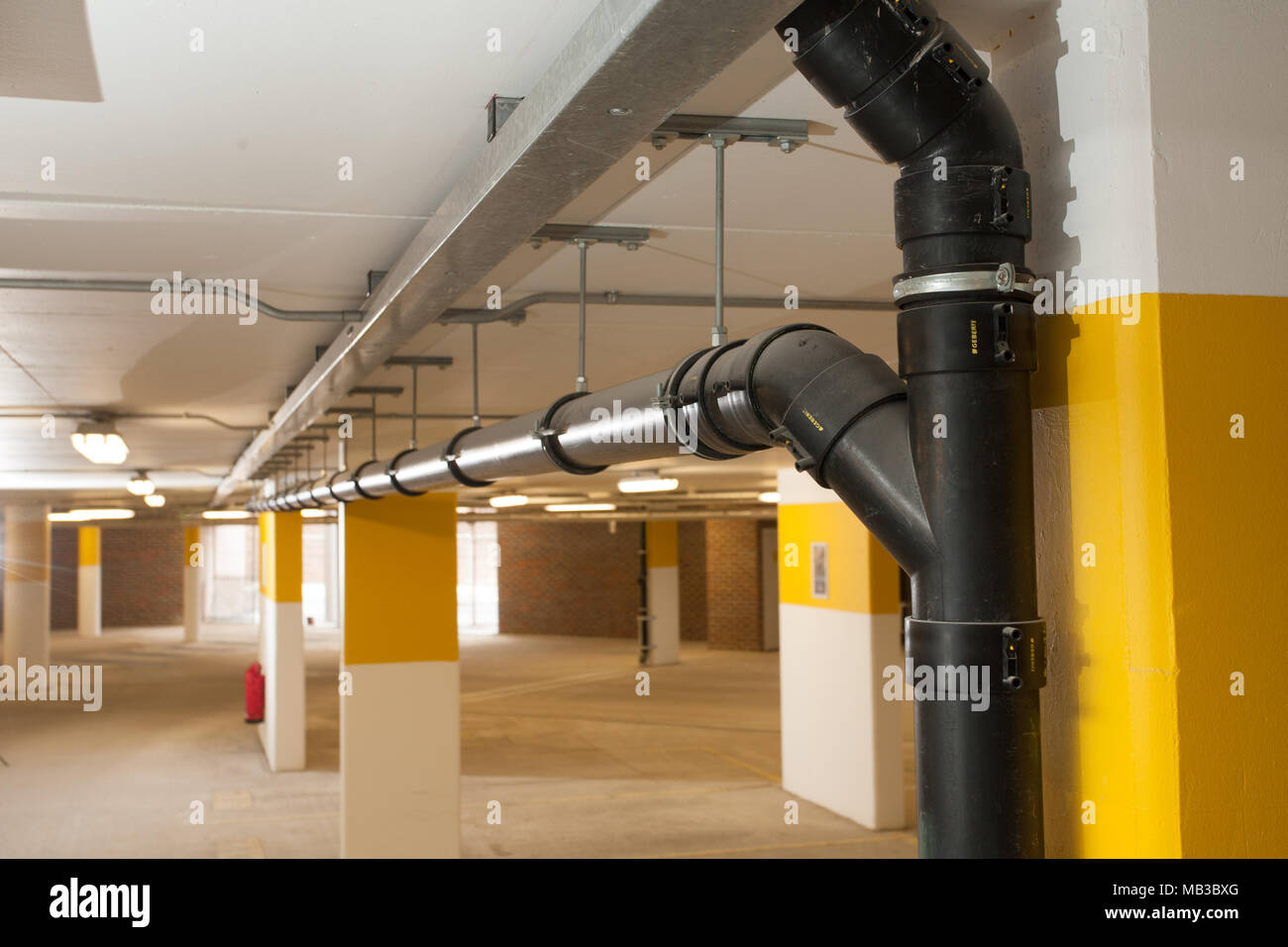 Sewage waste pipe system track emerging into a underground car park ...