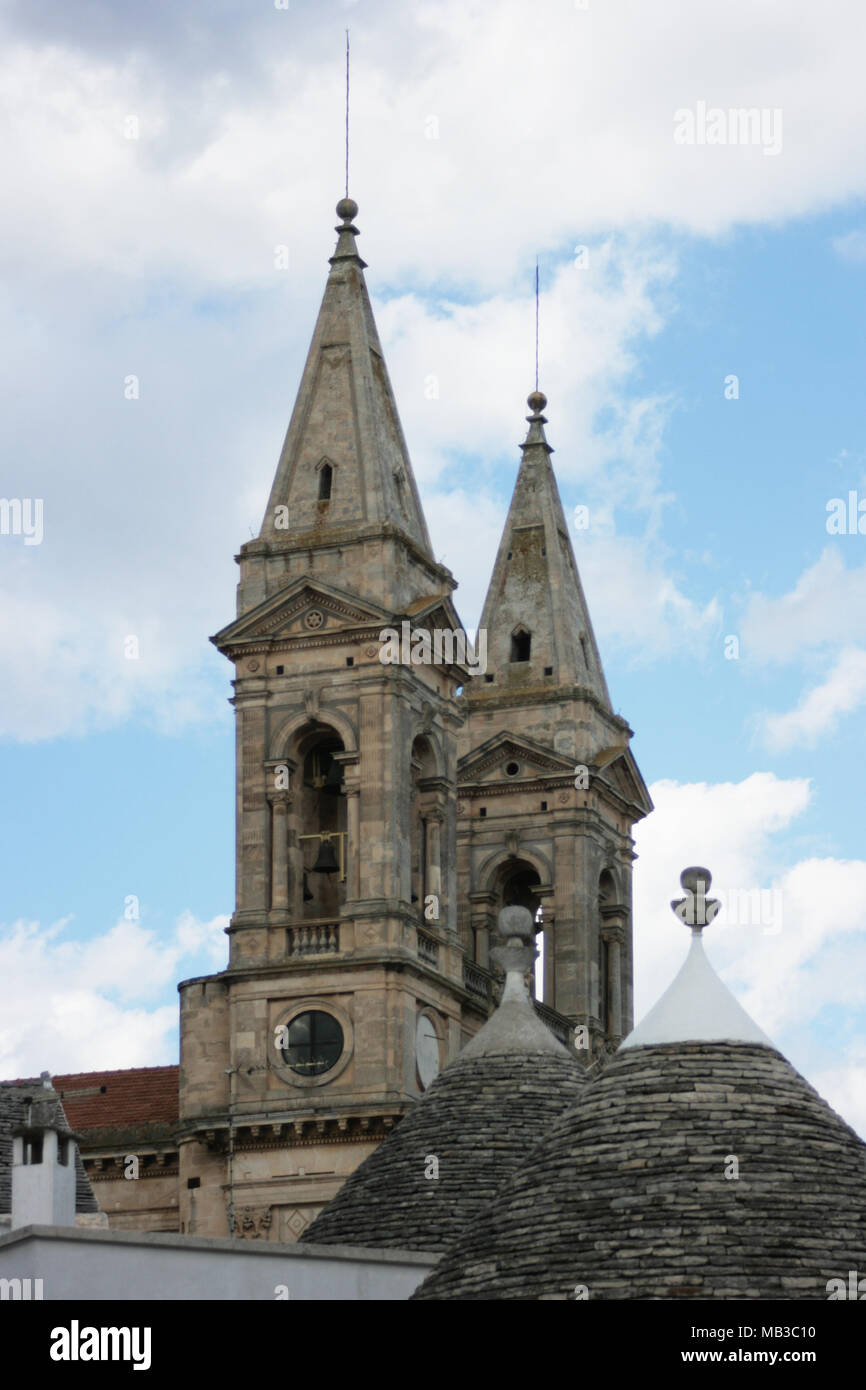 The cone-shaped roofs of two ancient Trulli reflect the shape of the ...