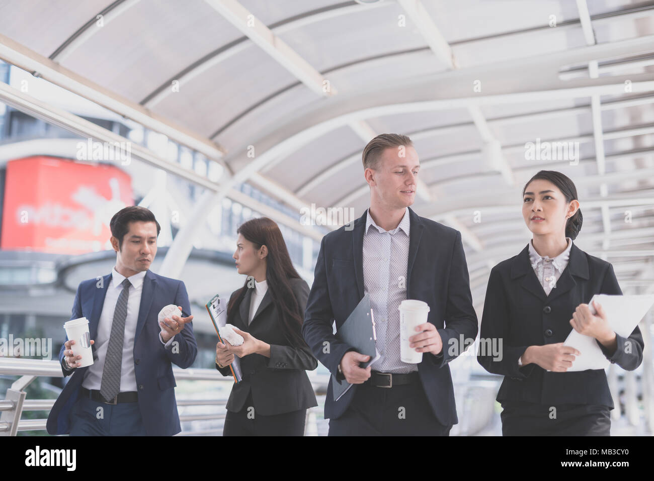 Happy Business colleagues walking outside office & talking to each ...