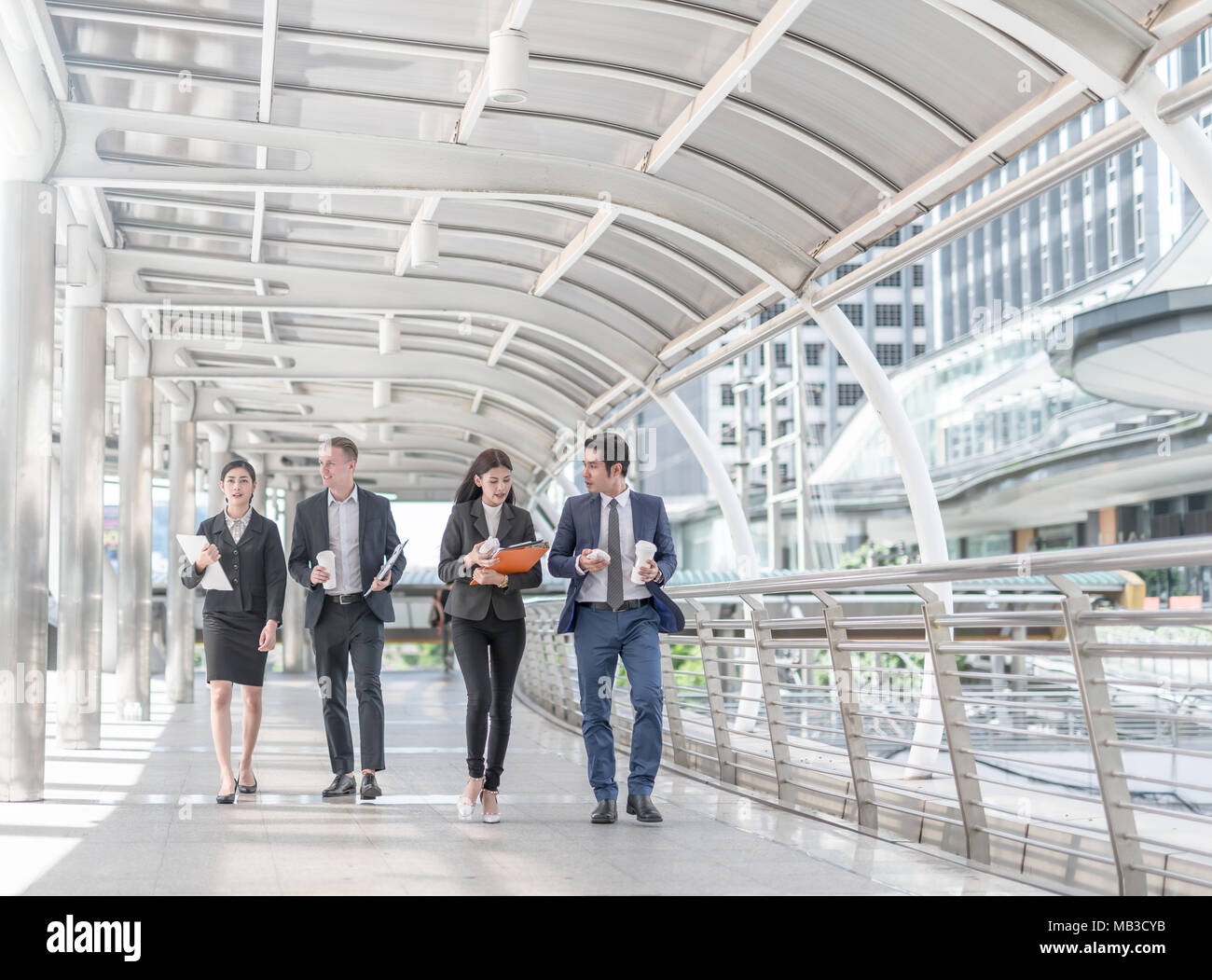 Happy Business colleagues walking outside office & talking to each ...