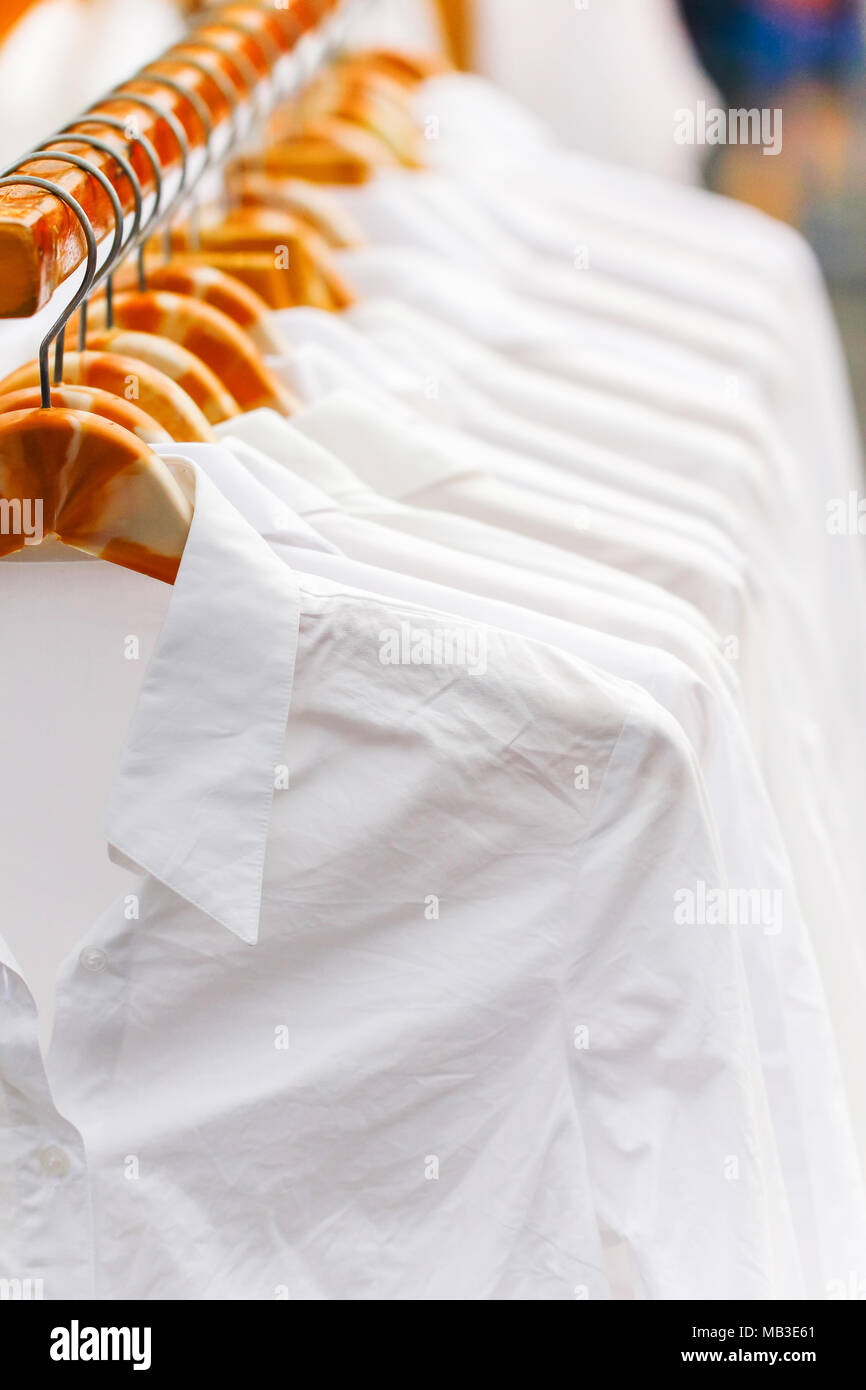 Crease white shirts hanging on rack in a row, Selective focus Stock ...
