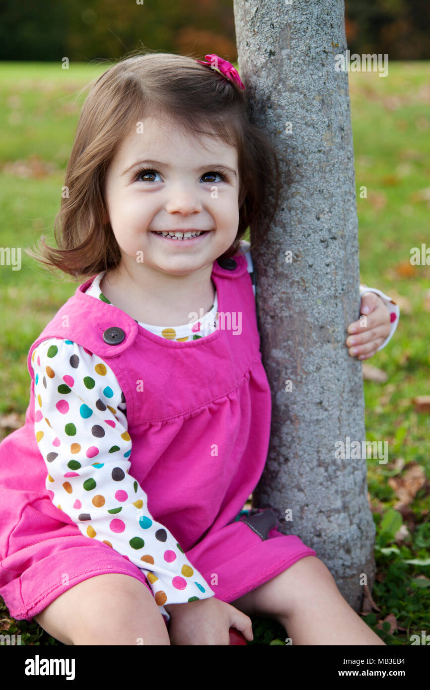Young girl with arm around tree hi-res stock photography and images - Alamy