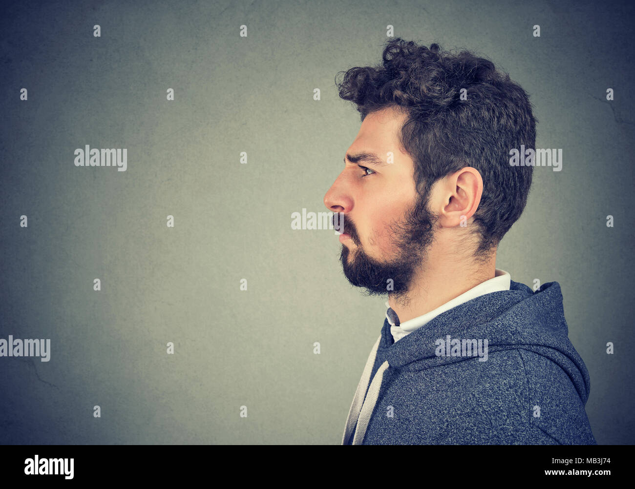 Portrait of a young man frowning Stock Photo - Alamy