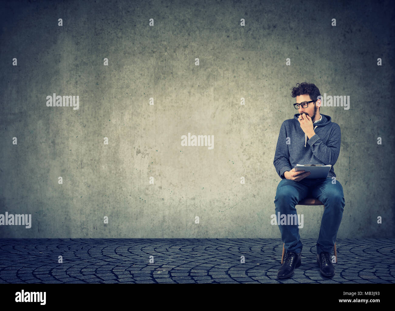 Anxious man sitting with resume anticipating interview, feeling nervous ...