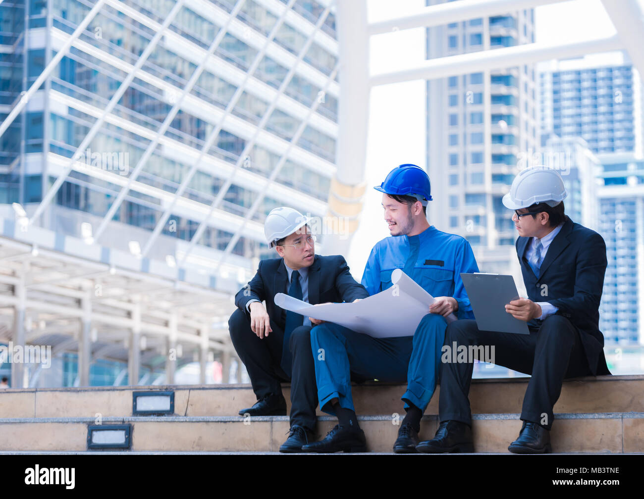 Business engineer planing with white helmet and holding drawing paper ...