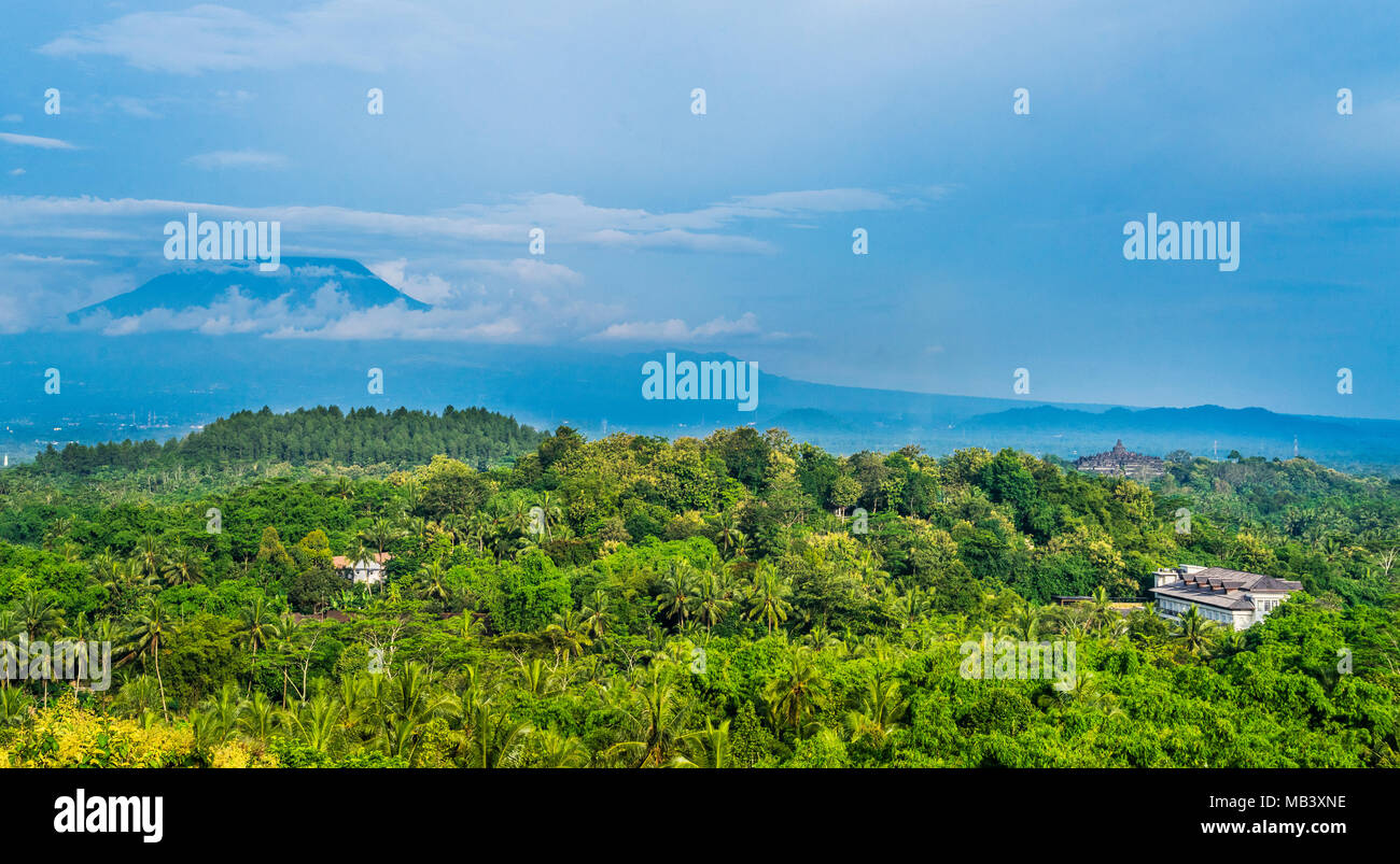 9th century Borobudor temple (right) rises from the lush greenery of ...
