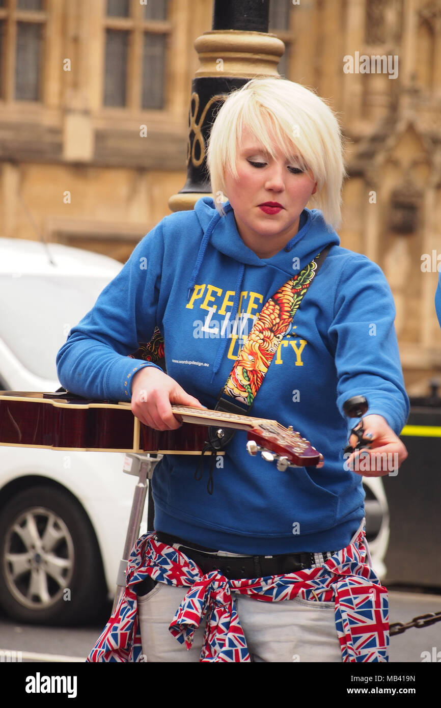A young woman protesting against Brexit by using music on her guitar to ...
