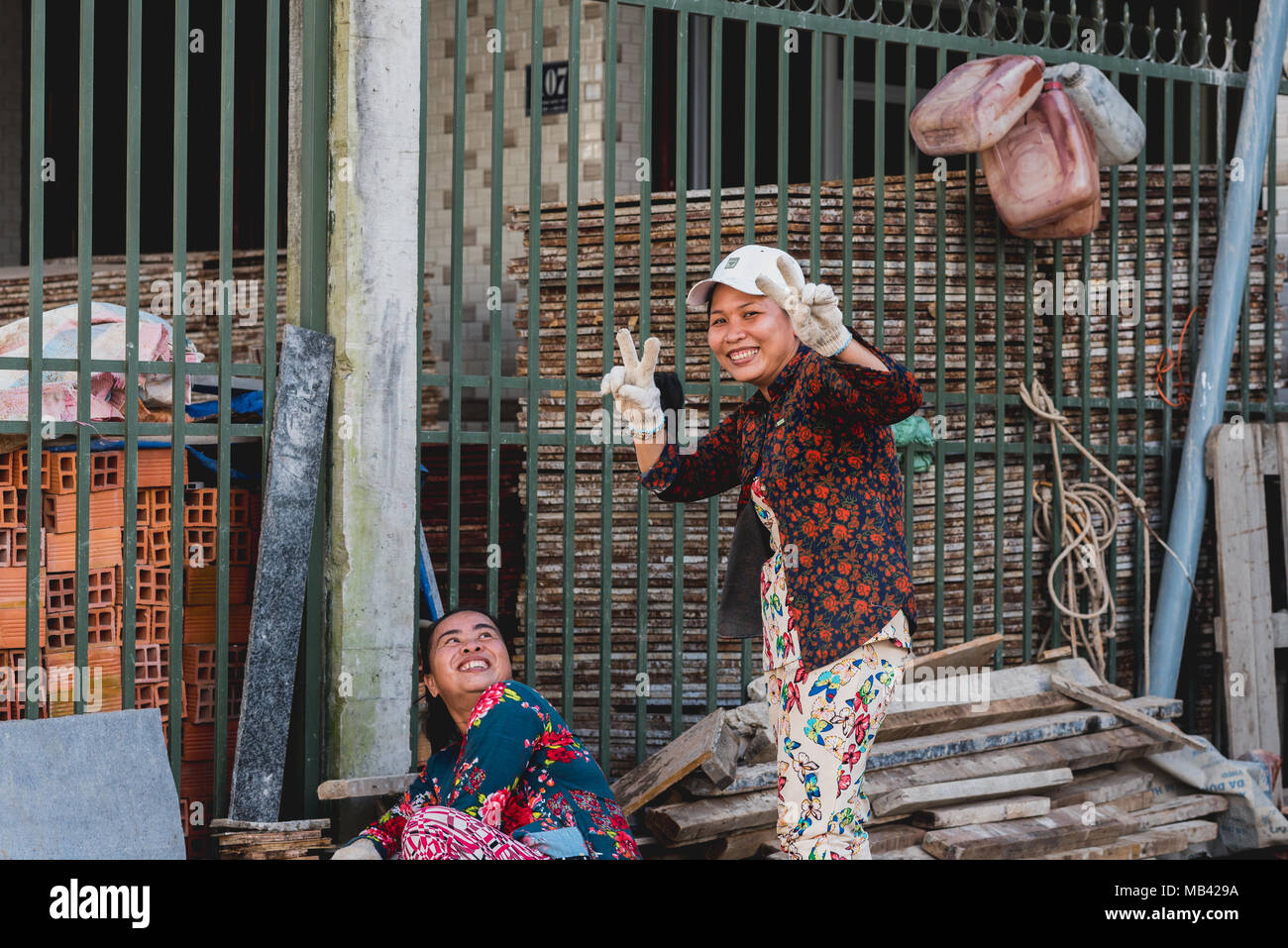 Two happy Vietnamese women work in construction. They pose and smile ...