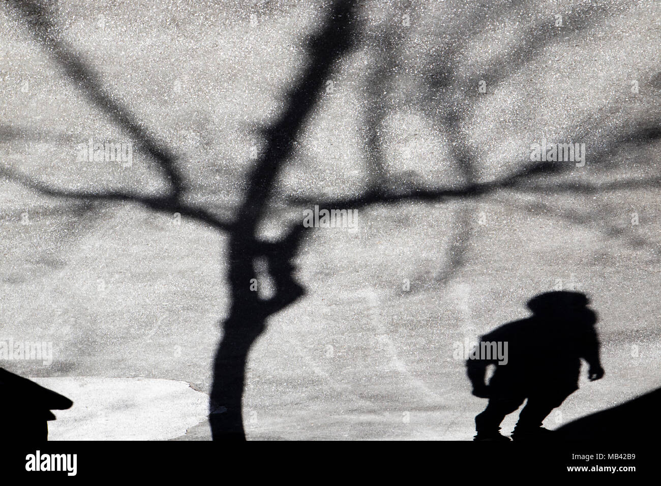 Abstract blurry silhouette shadows of a man standing alone under a bare ...