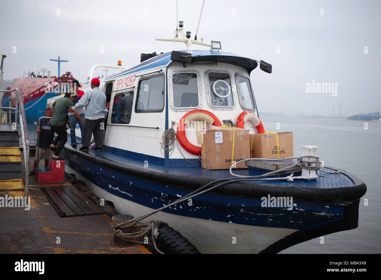 Passengers boarding a sail boat anchored at a Malaysian sea port Stock ...