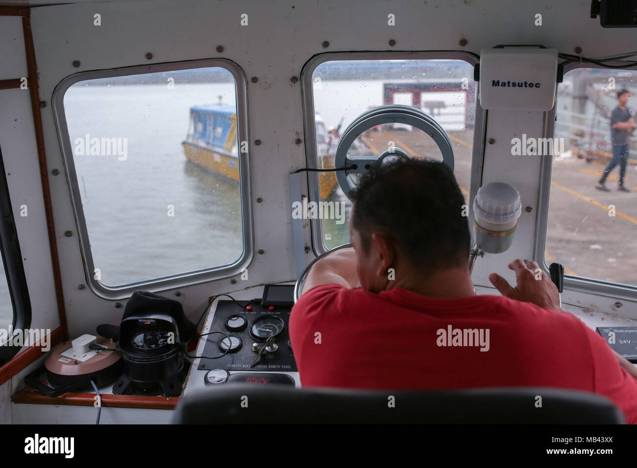 Boat operator at the helm of a private sea boat Stock Photo - Alamy