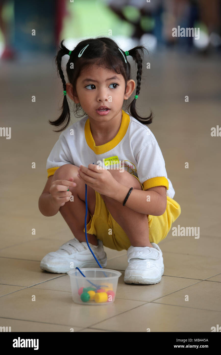 Children are in the game of threading the beads during their ...