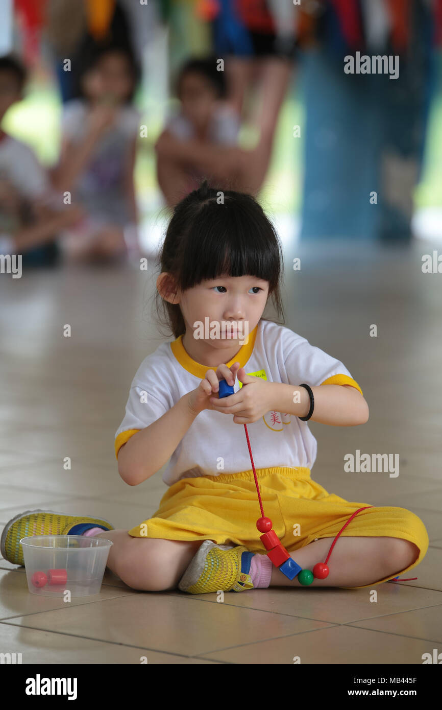 Children are in the game of threading the beads during their ...