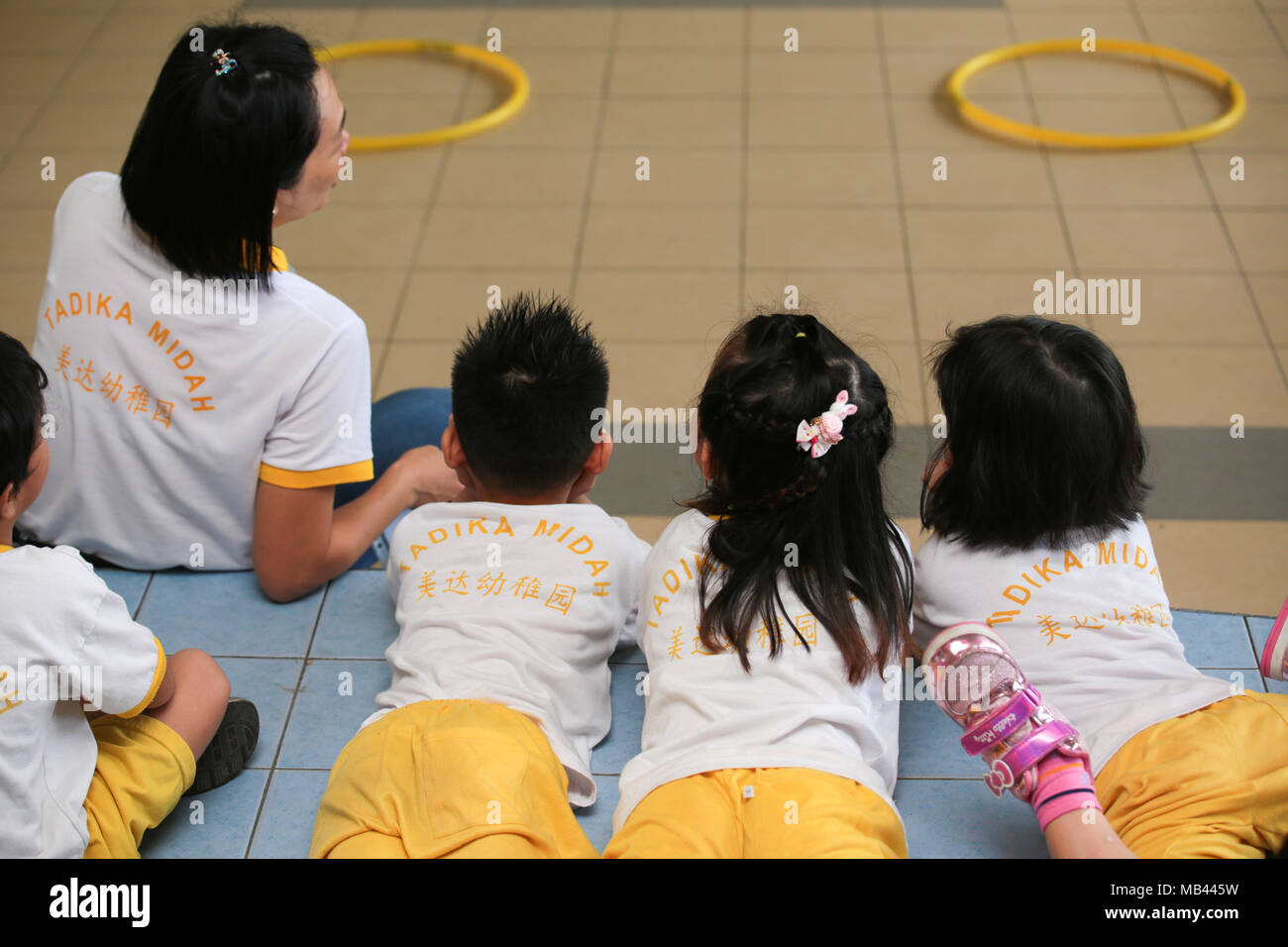 Children chatting with their teacher at their kindergarten sport day ...