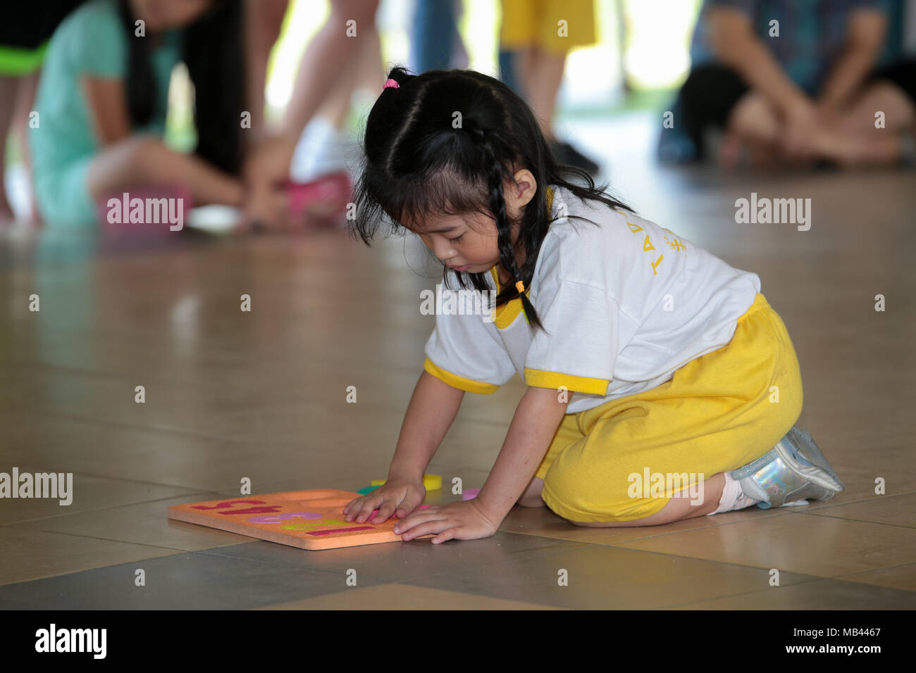 A child is trying to finish her puzzle block during their kindergarten ...