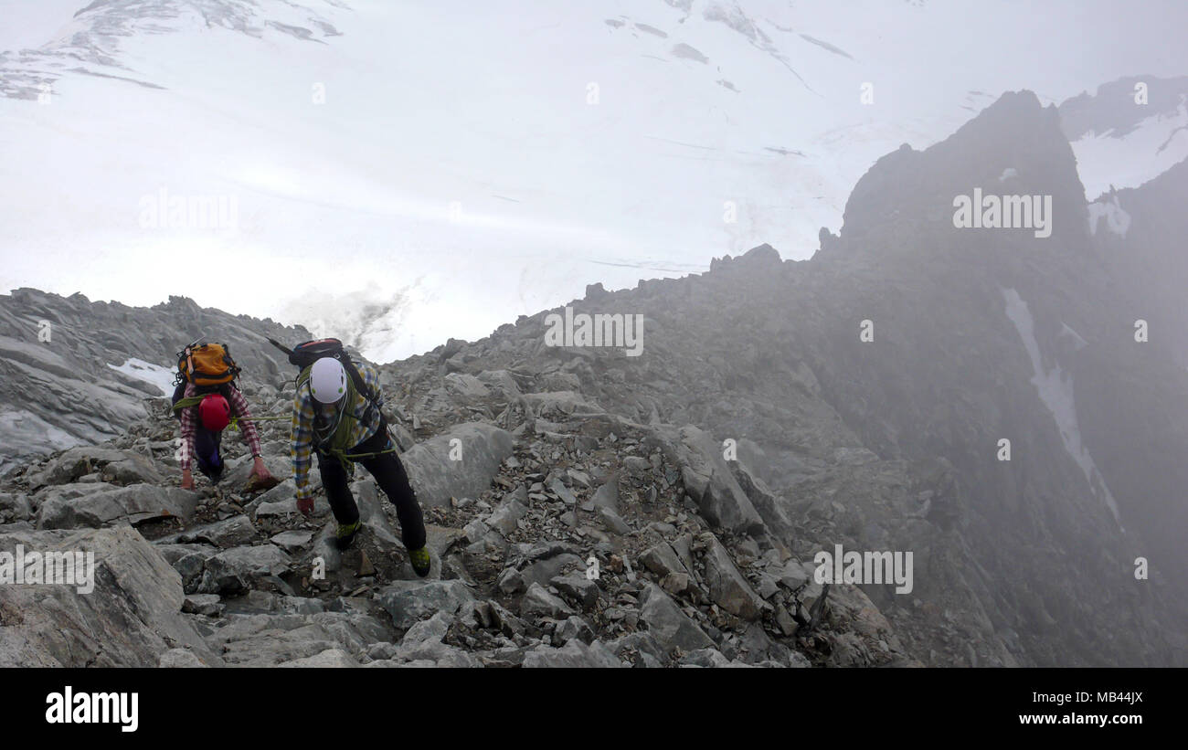 mountain guide and client heading towards a high alpine summit on a ...