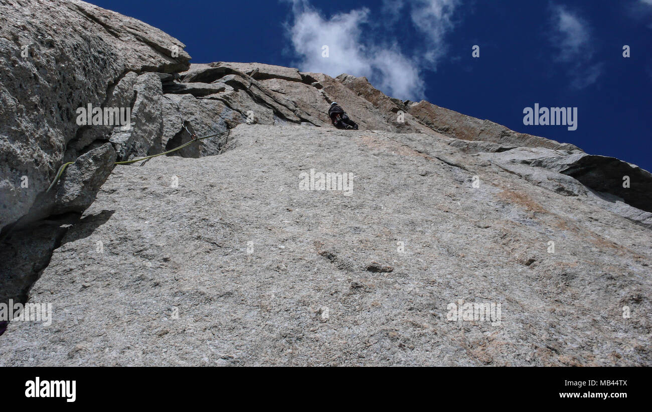 male rock climber on a steep granite route in the mountains near ...