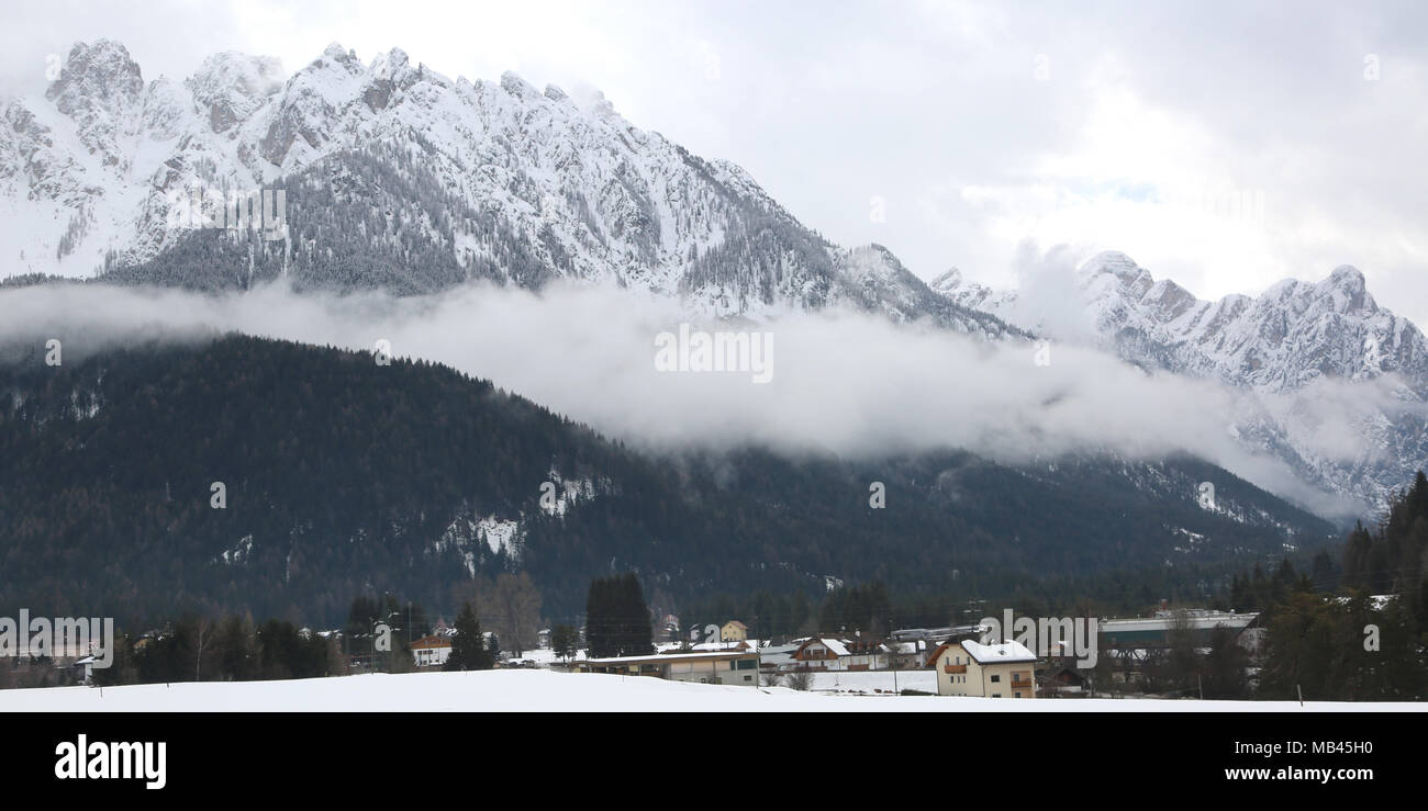 alpine landscape of south Tyrol with mountain peaks with snow and mist ...