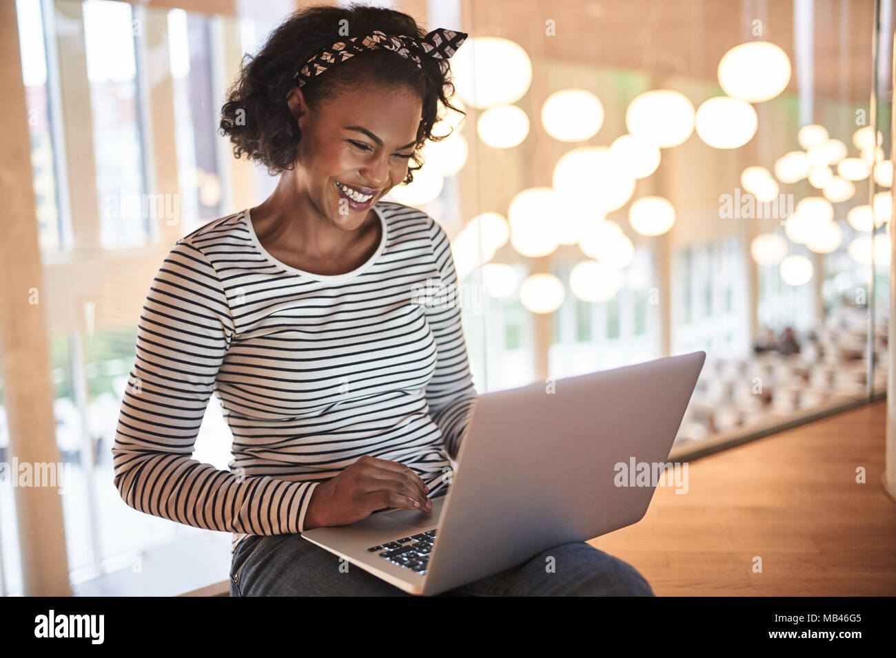 Young African college student smiling and working online with a laptop ...