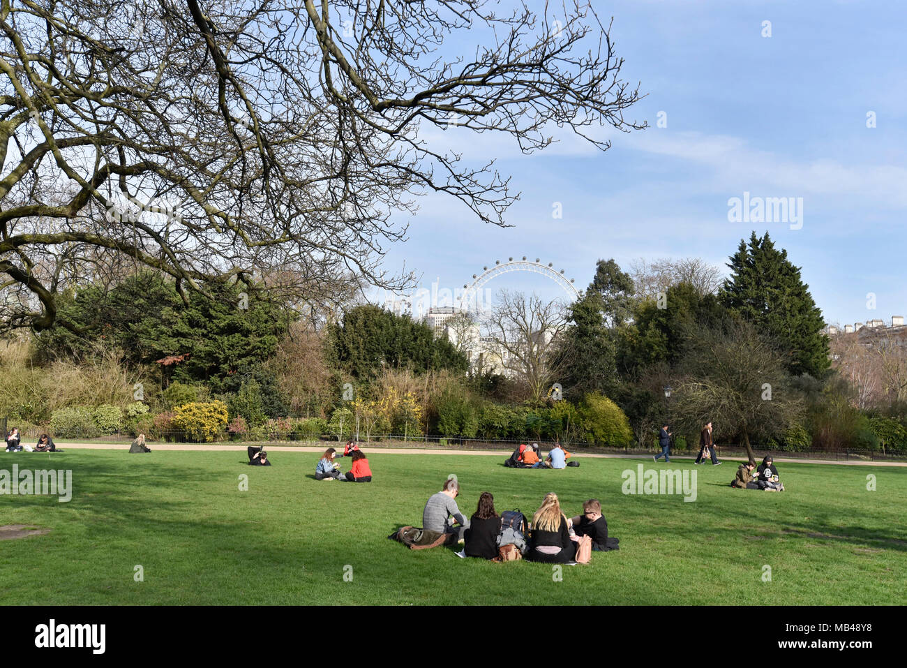 London, UK. 6 April 2018. UK Weather - Tourists relax in St James's ...