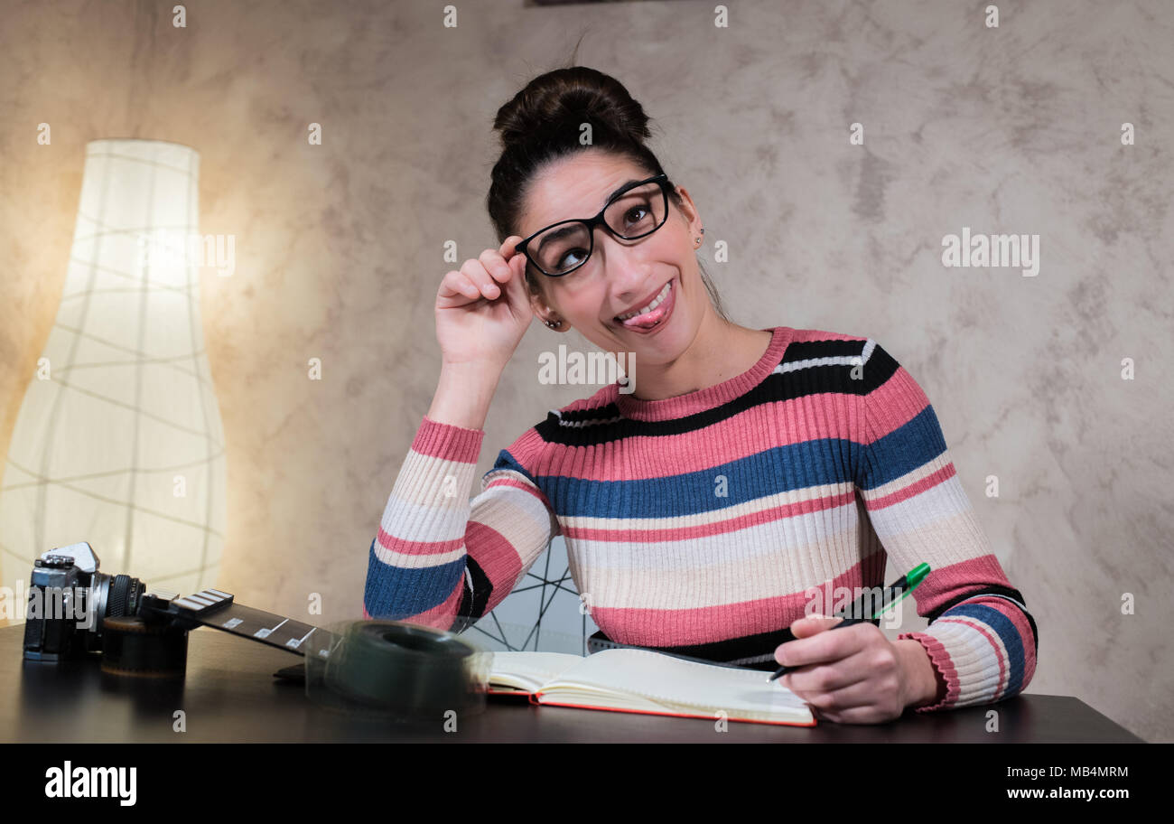 Young attractive woman thoughtful working writing script with movie ...