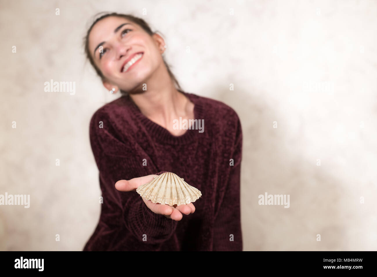 Human hands with sea shell offering and giving, woman smiling out of ...