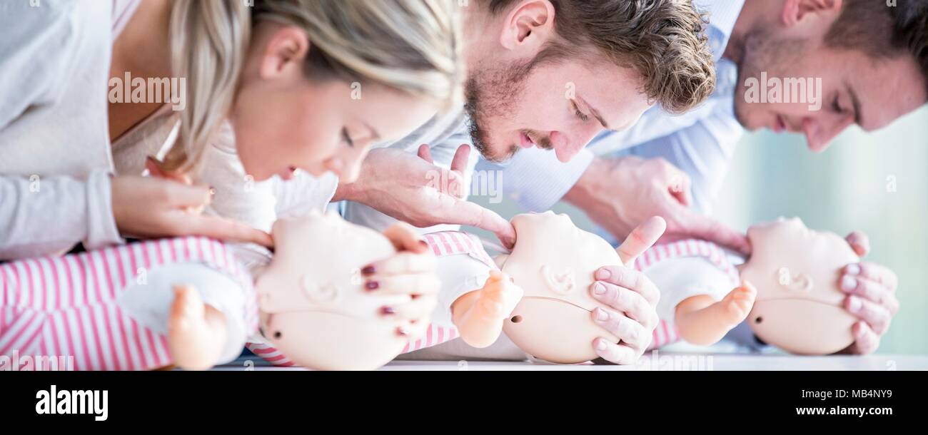 MODEL RELEASED. Doctor practising infant CPR on training dummies Stock ...