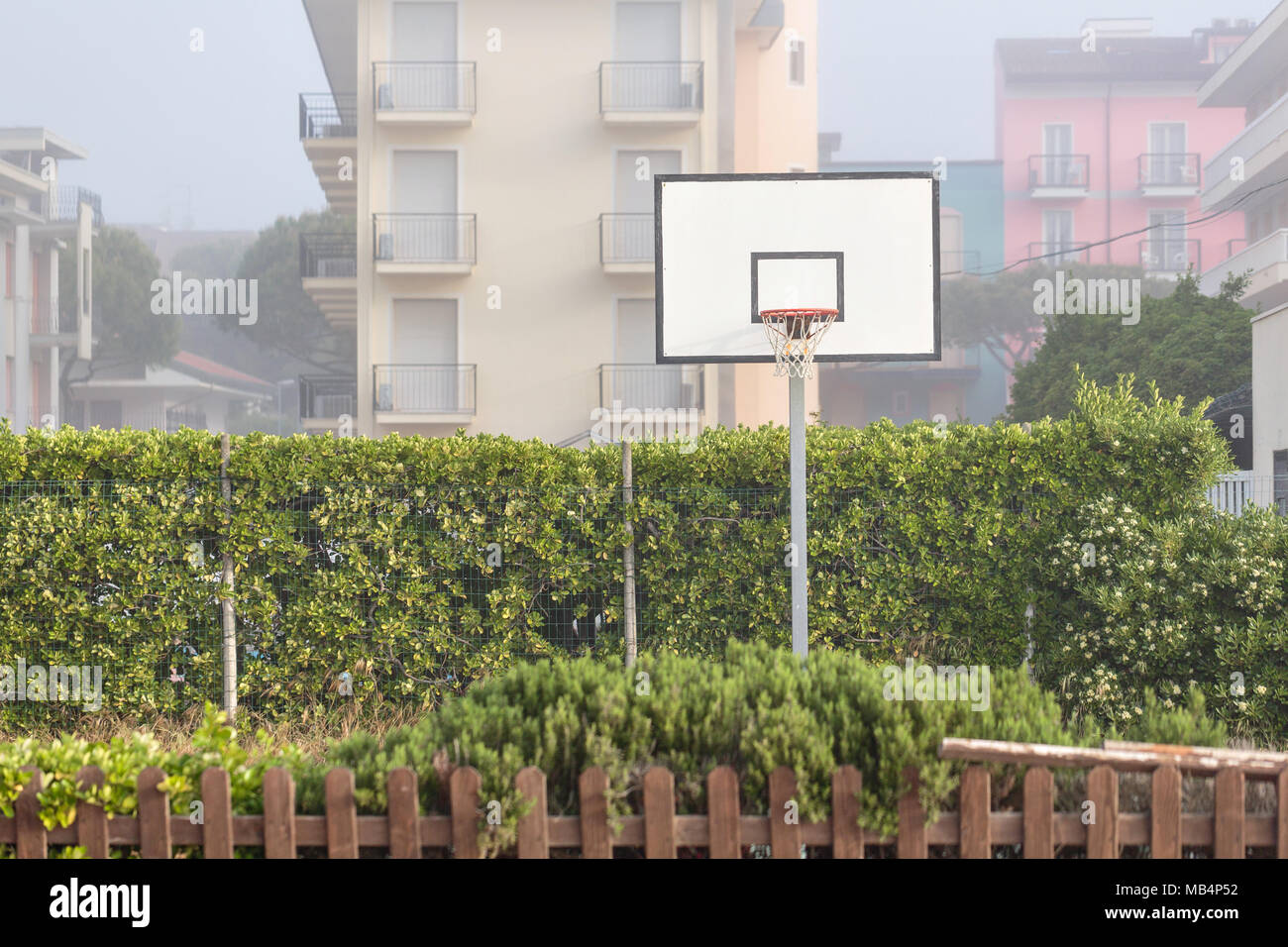 Basketball structure in an outdoor playground surrounded by trees in a ...