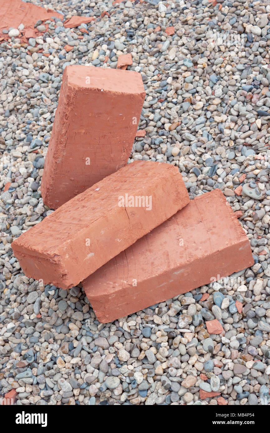 Three red clay bricks lying on the gravel Stock Photo - Alamy