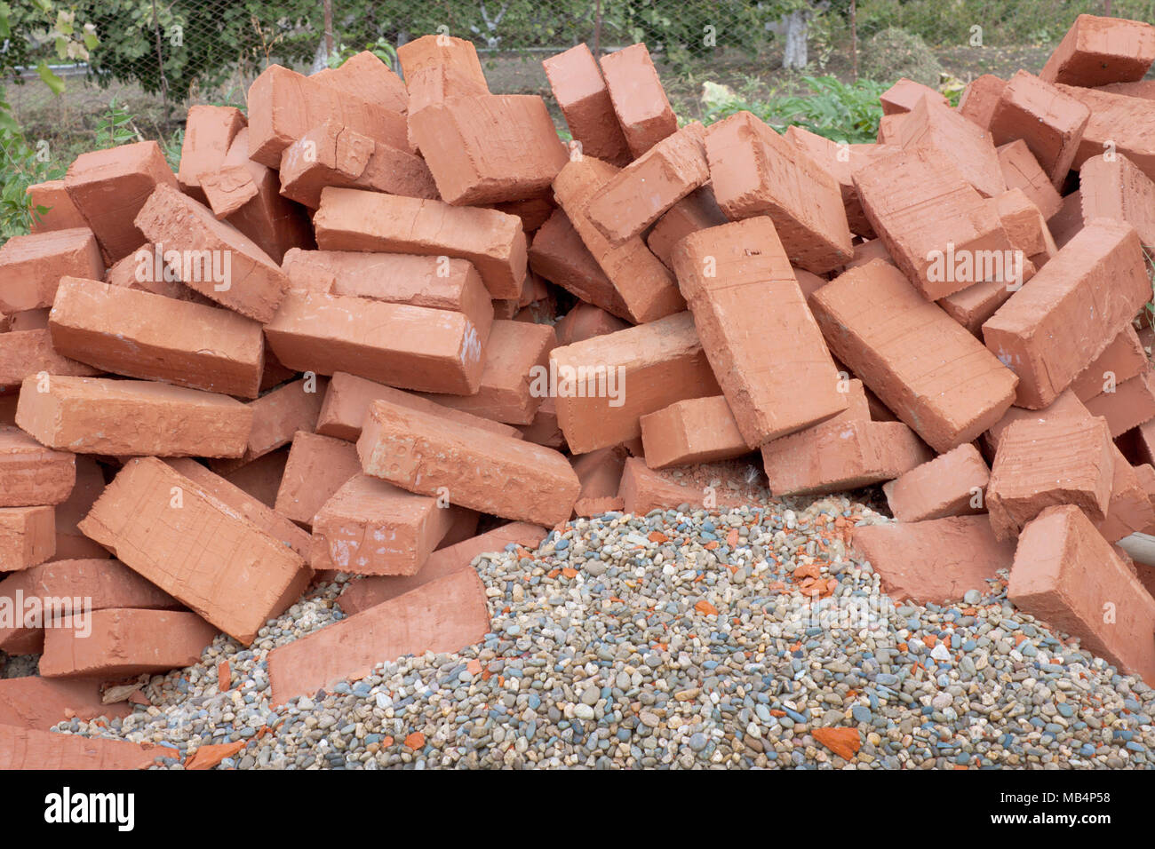 Lots red clay bricks lying on the gravel Stock Photo - Alamy