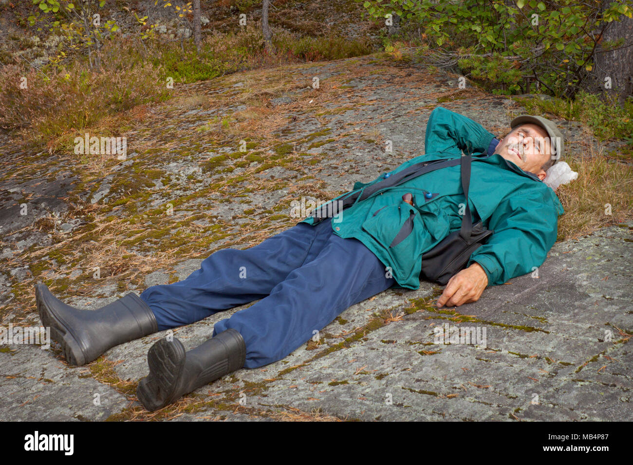 An elderly tourist resting lying on the rock Stock Photo - Alamy