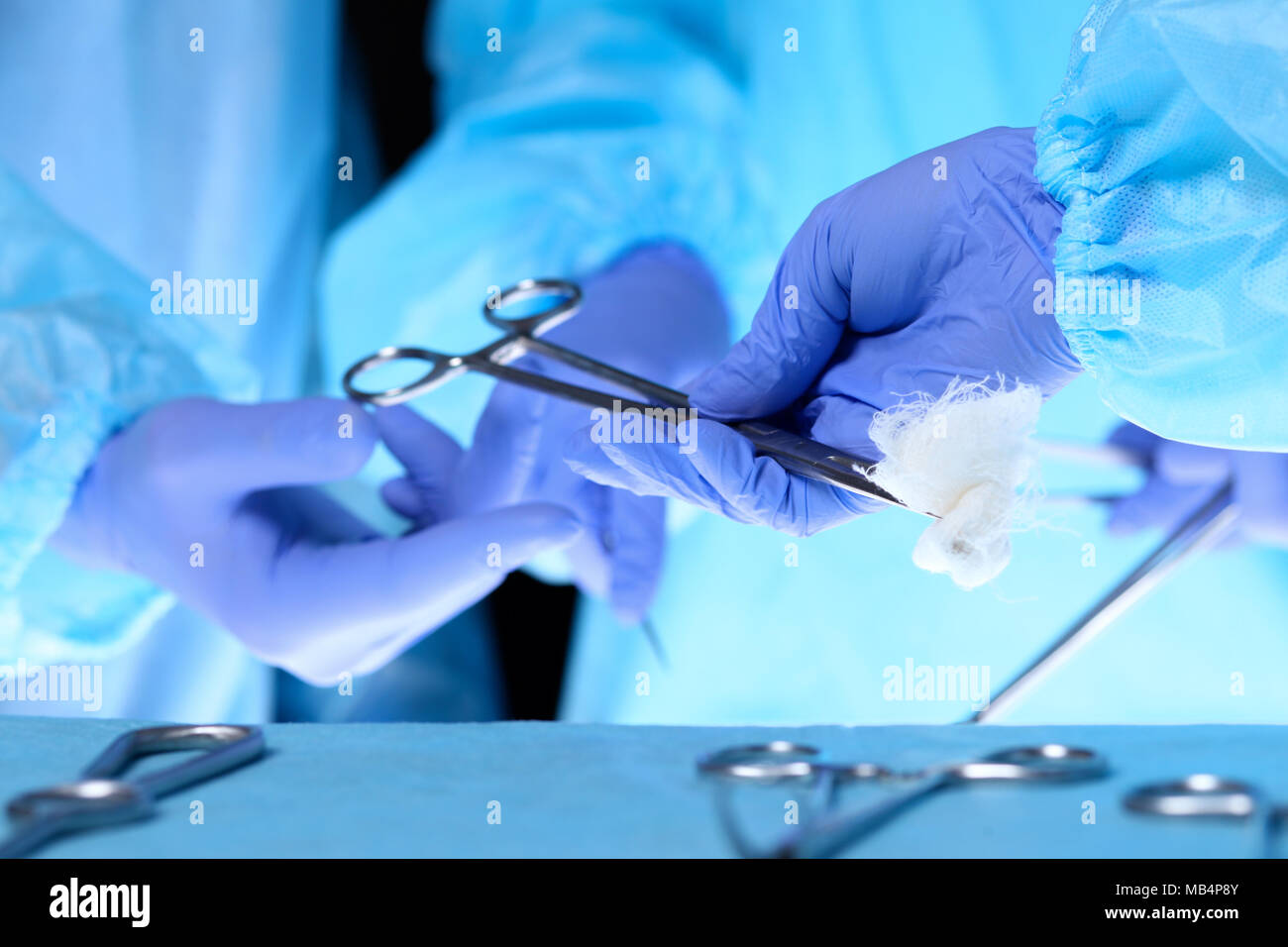 Surgeons hands holding surgical scissors and passing surgical equipment ...