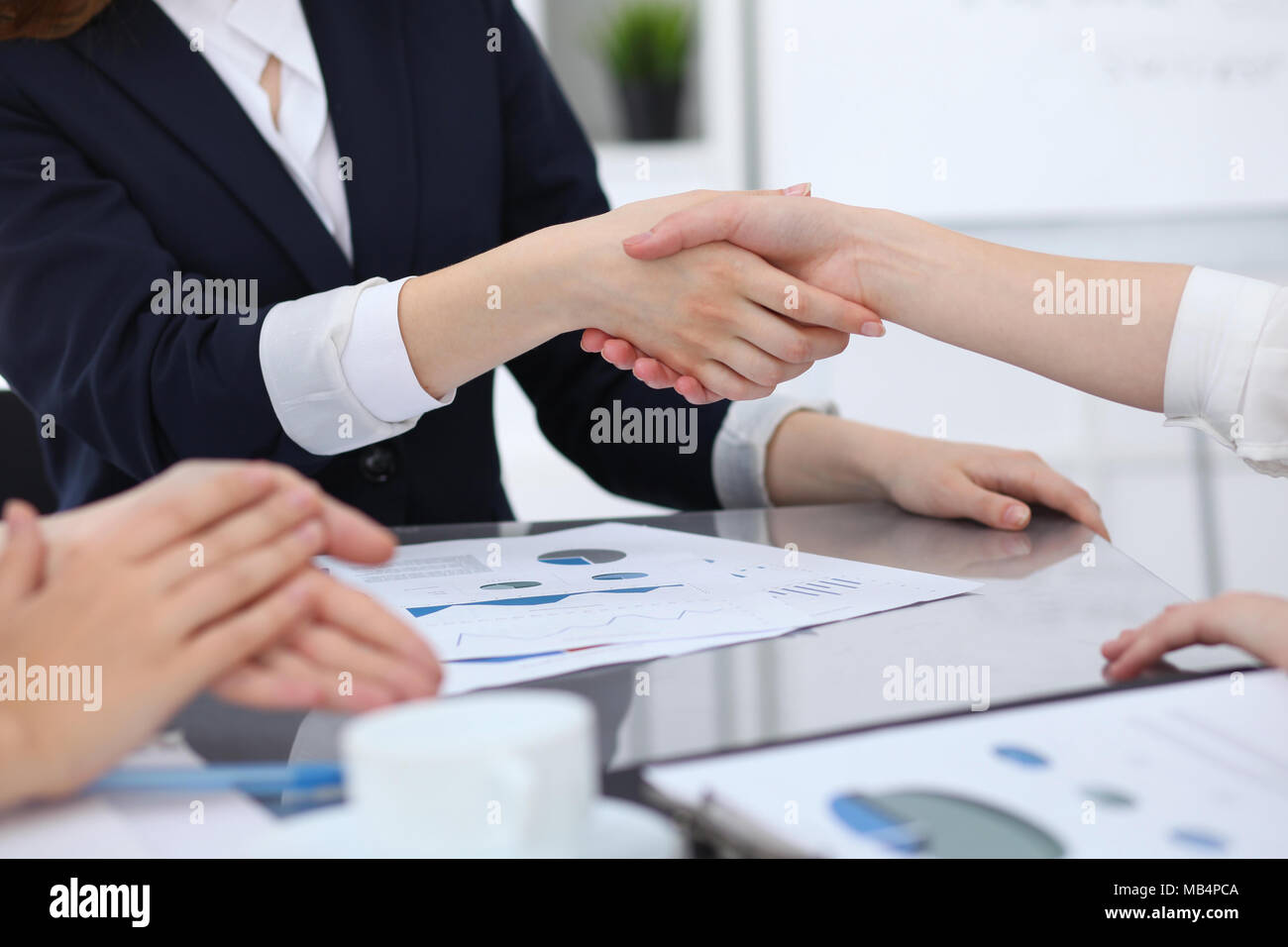 Close Up of unknown business people shaking hands while finishing up a ...