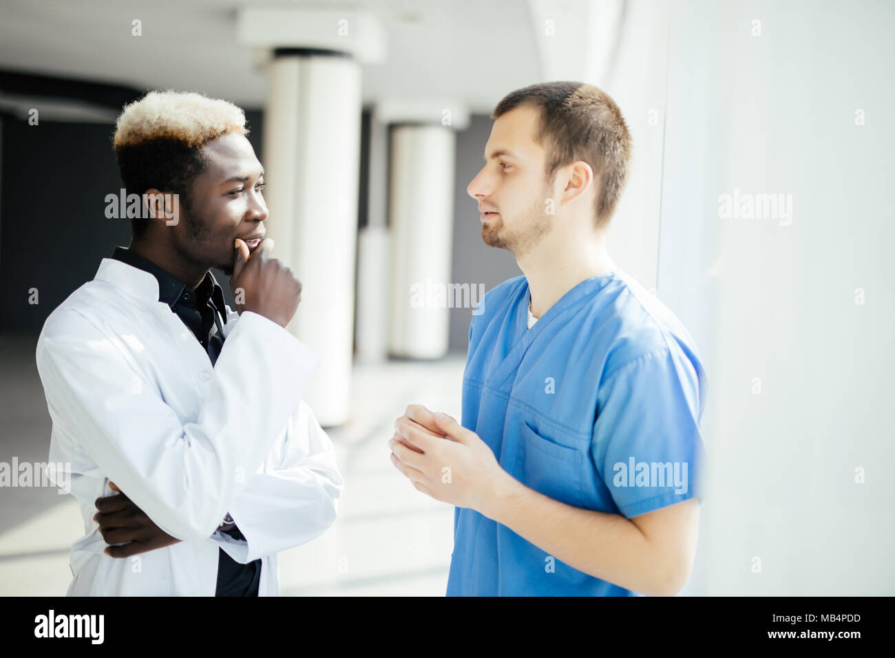 View Of Doctors Talking As They Walk Through Hospital Stock Photo - Alamy