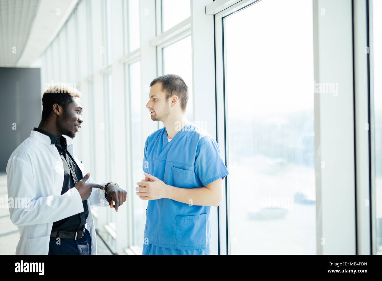 Doctoral meeting. Two Confident doctor standing in hospital and discuss ...