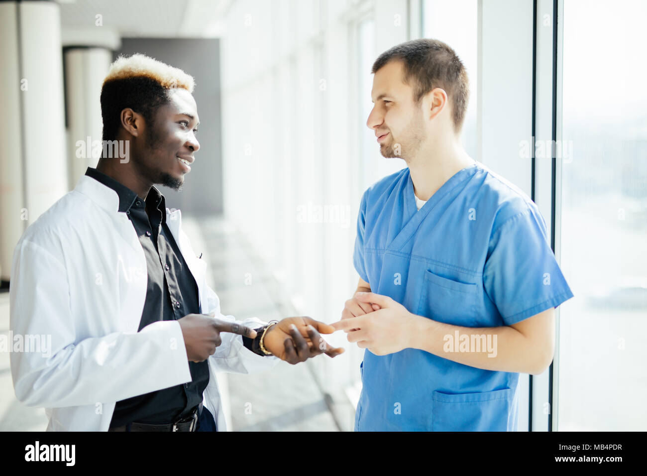 Two Doctors Talking As They Walk Through Modern Hospital Stock Photo ...