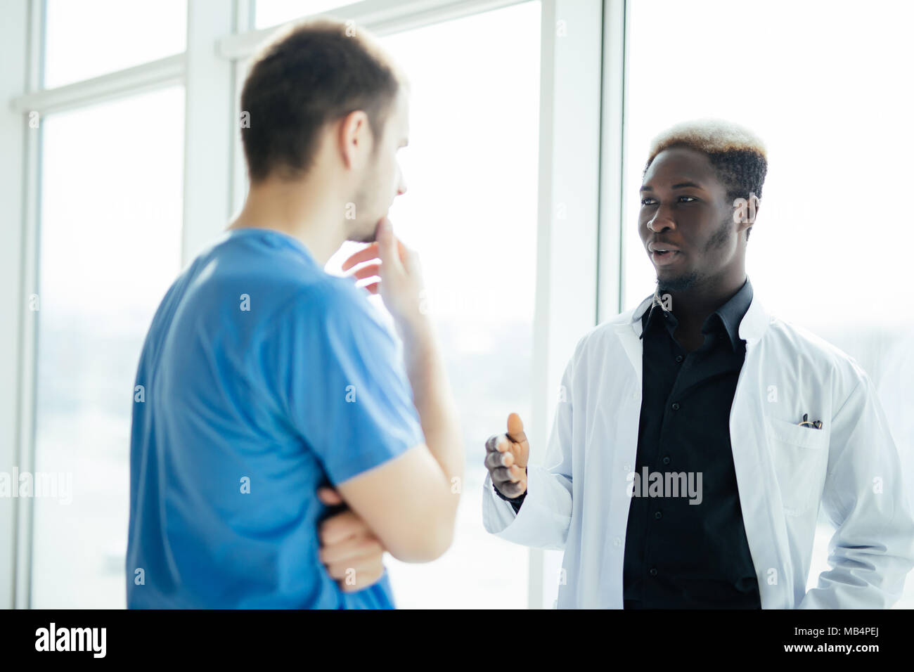 Doctoral meeting. Two Confident doctor standing in hospital and discuss ...