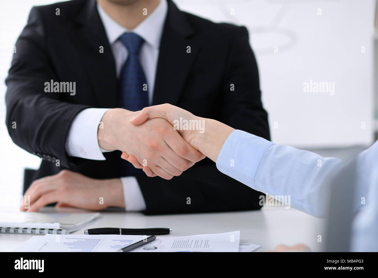 Close Up of unknown business people shaking hands while finishing up a ...