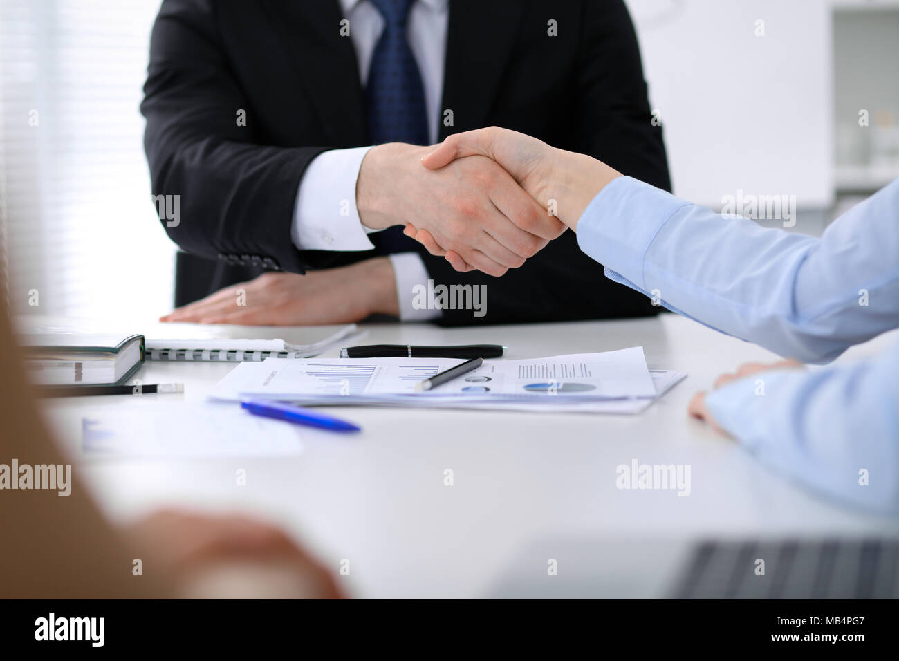 Close Up of unknown business people shaking hands while finishing up a ...