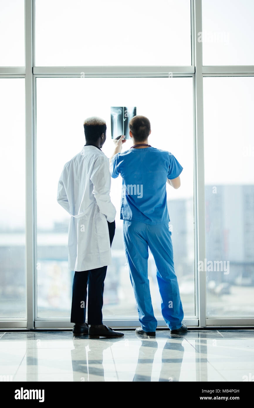 Two mixed race doctors with x-ray scan at modern hospital Stock Photo ...
