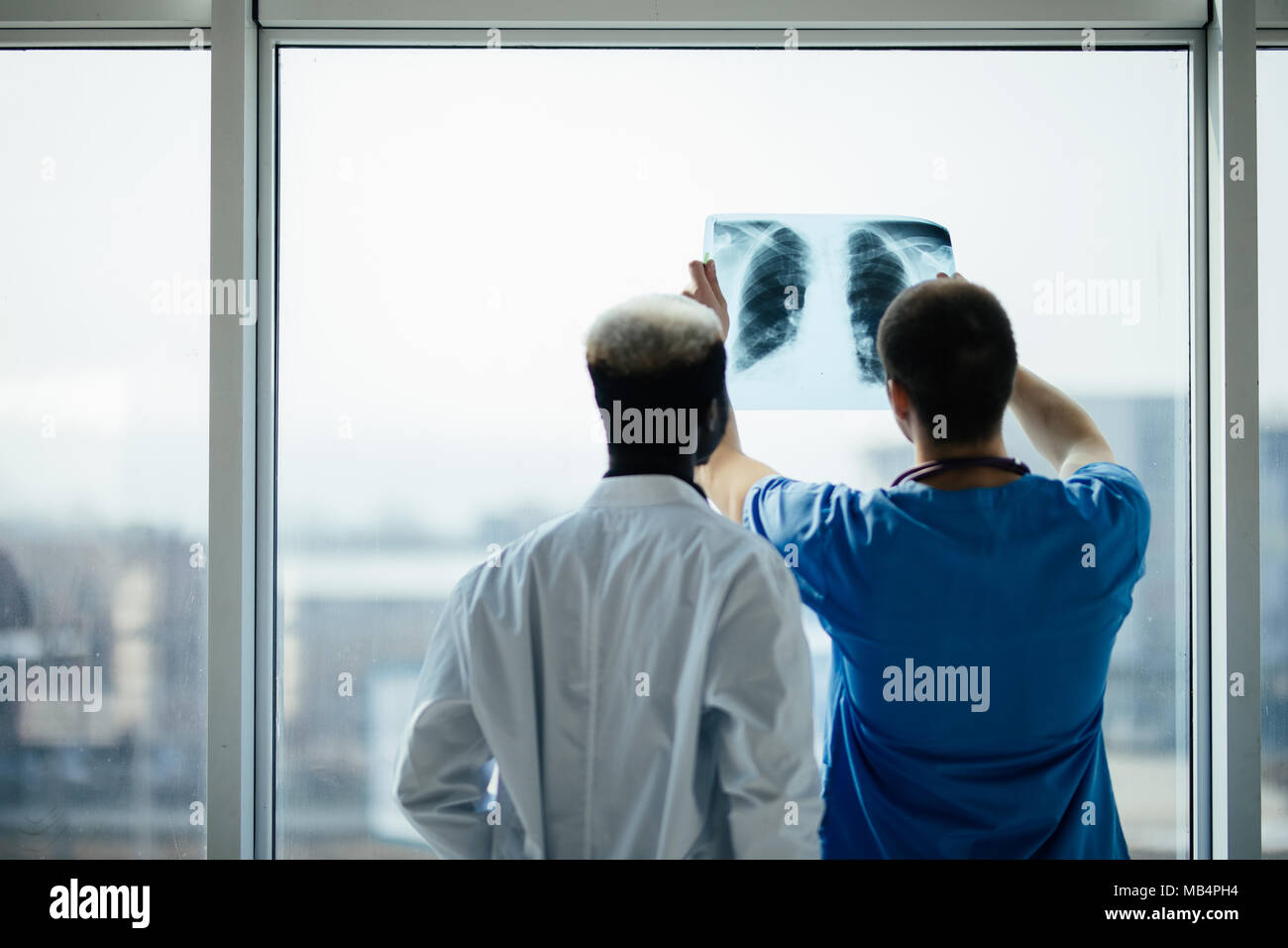 Two mixed race doctors with x-ray scan at modern hospital Stock Photo ...