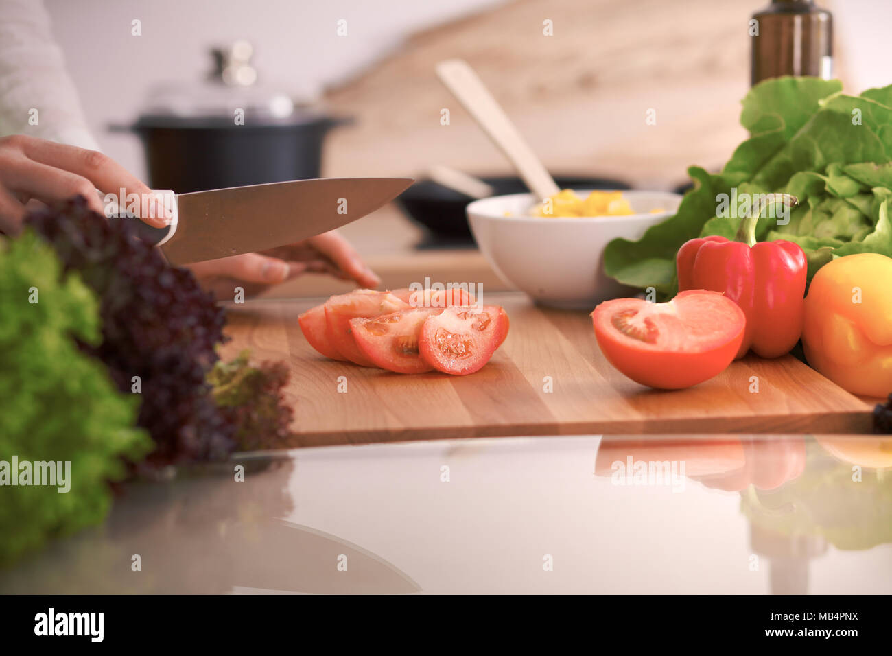 Close Up of human hands cooking vegetable salad in kitchen on the glass ...
