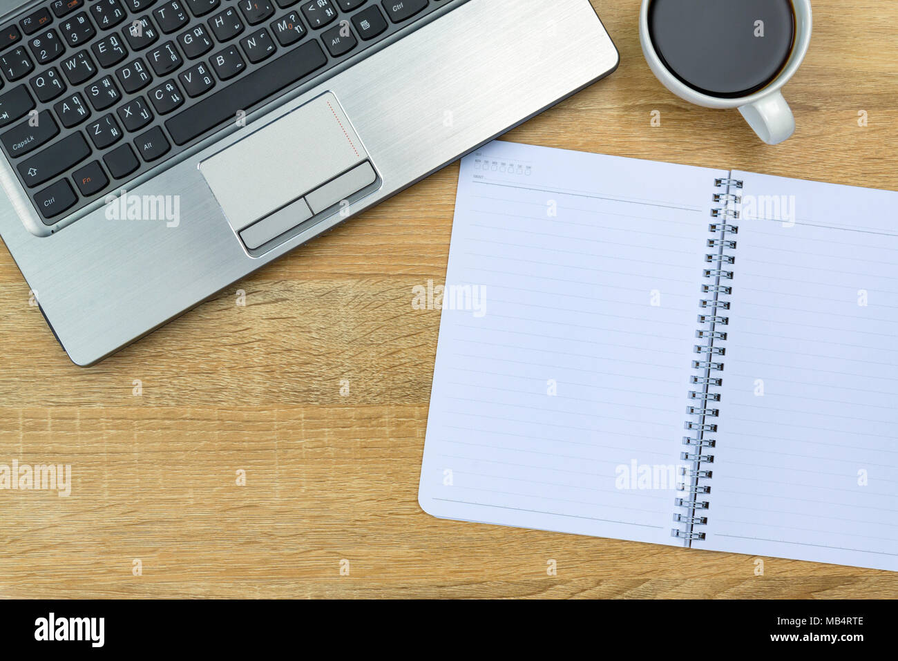 Laptop computer or notebook, note and cup of coffee on working table or ...