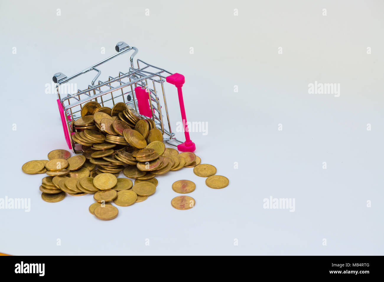 Stack of coins and shopping cart or supermarket trolley on white ...