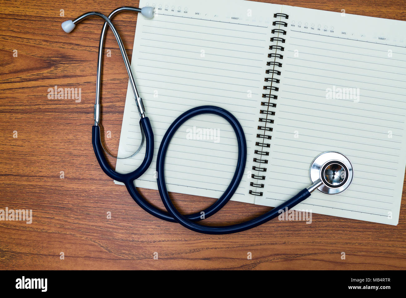Stethoscope and notebook on bright wood table top view with copy space ...